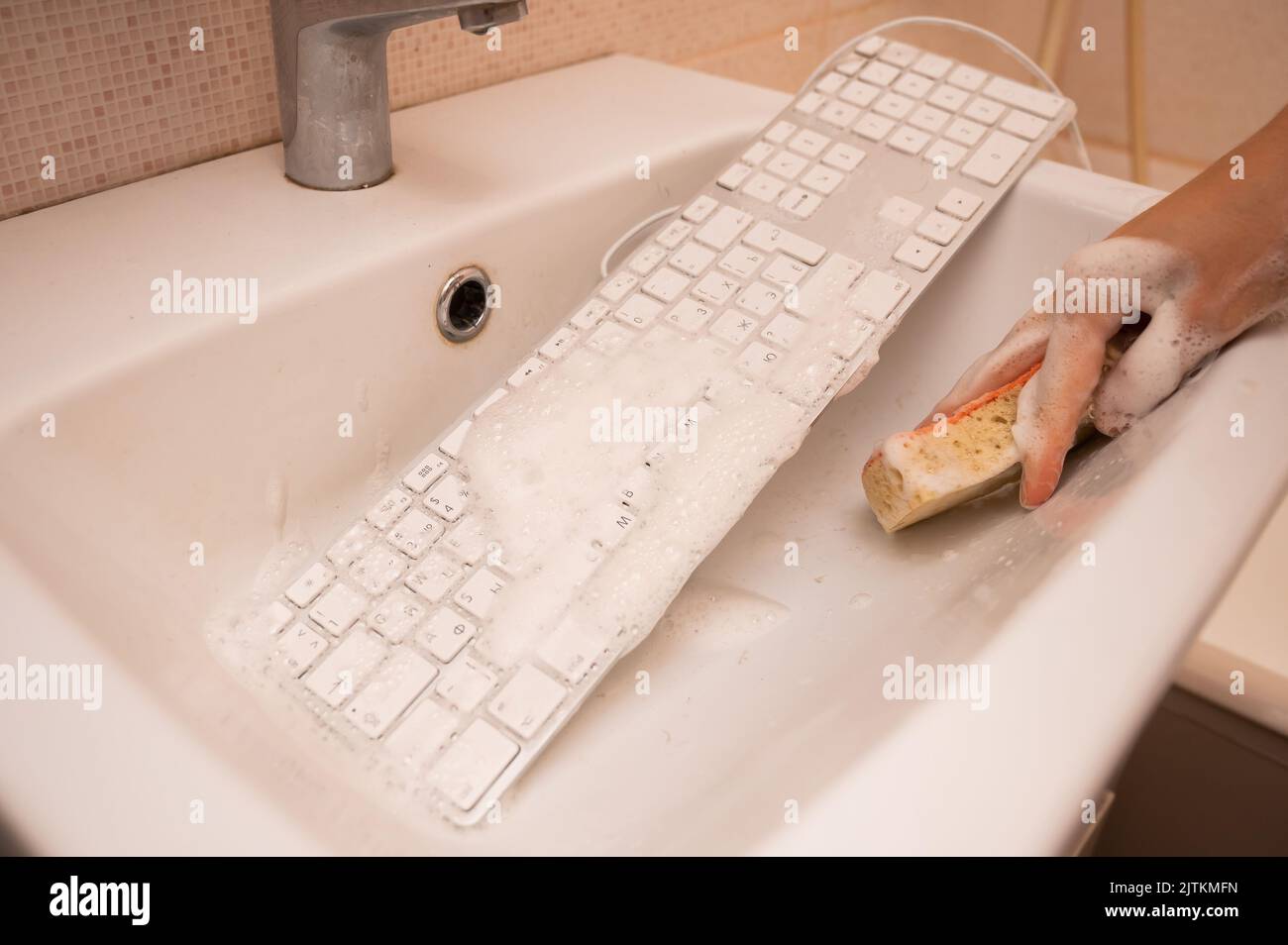 Woman washing white computer keyboard with a sponge with foam Stock ...