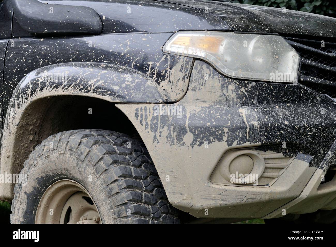 SUV covered in mud. The wheels and body of the car are splattered with ...