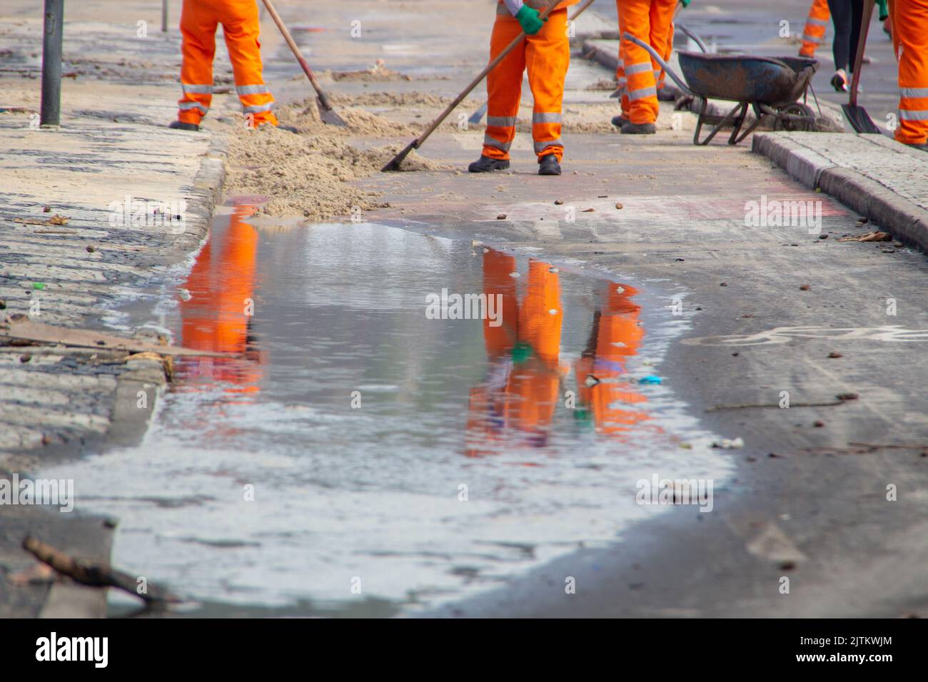 cleaning workers removing sand from the Leblon beach boardwalk in Rio ...