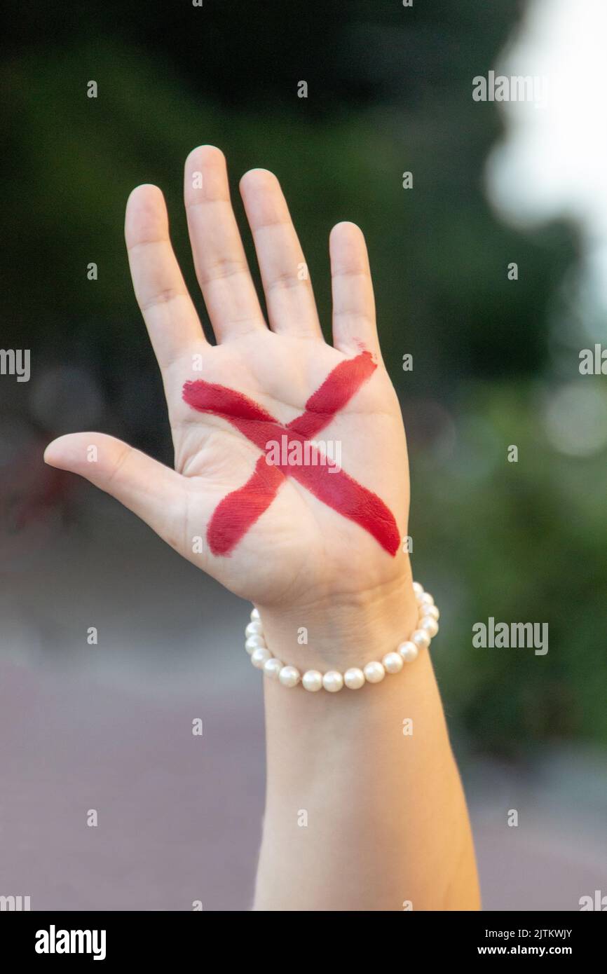female hand with red x, symbolizing the campaign against domestic ...