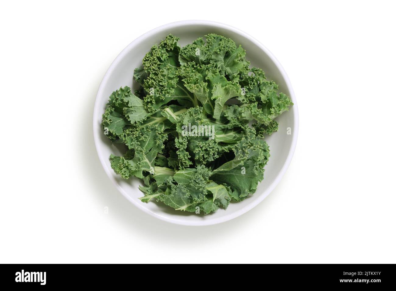 Chopped kale in a white bowl, shot from above isolated on white with ...