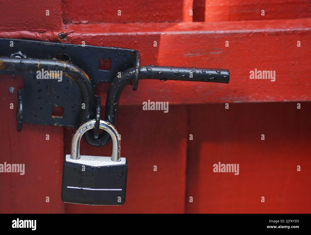 A closed metal lock on a red-painted door Stock Photo - Alamy