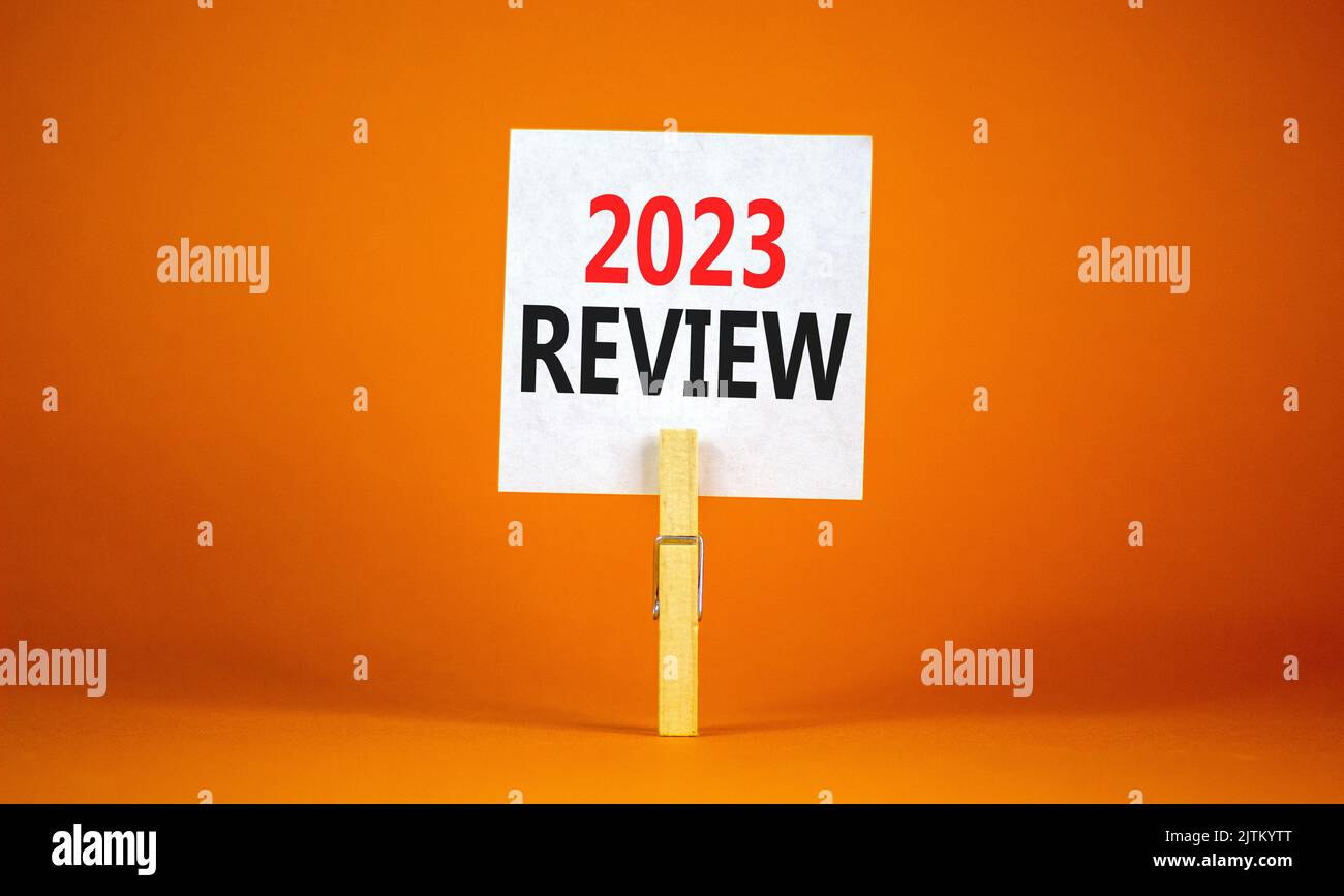 2023 Review symbol. White paper with words 2023 Review, clip on wooden ...