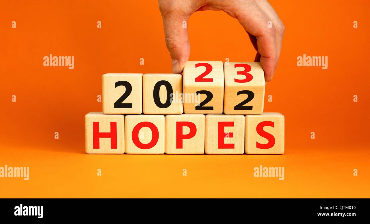 2023 hopes new year symbol. Businessman turns a wooden cube and changes ...