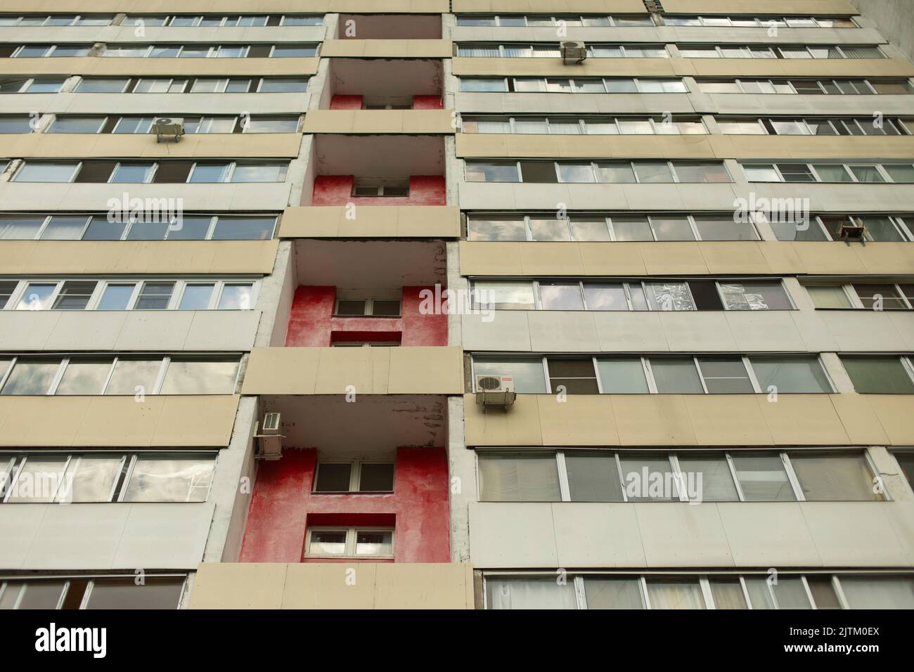 Residential building with red wall. Windows in house. Glass on ...