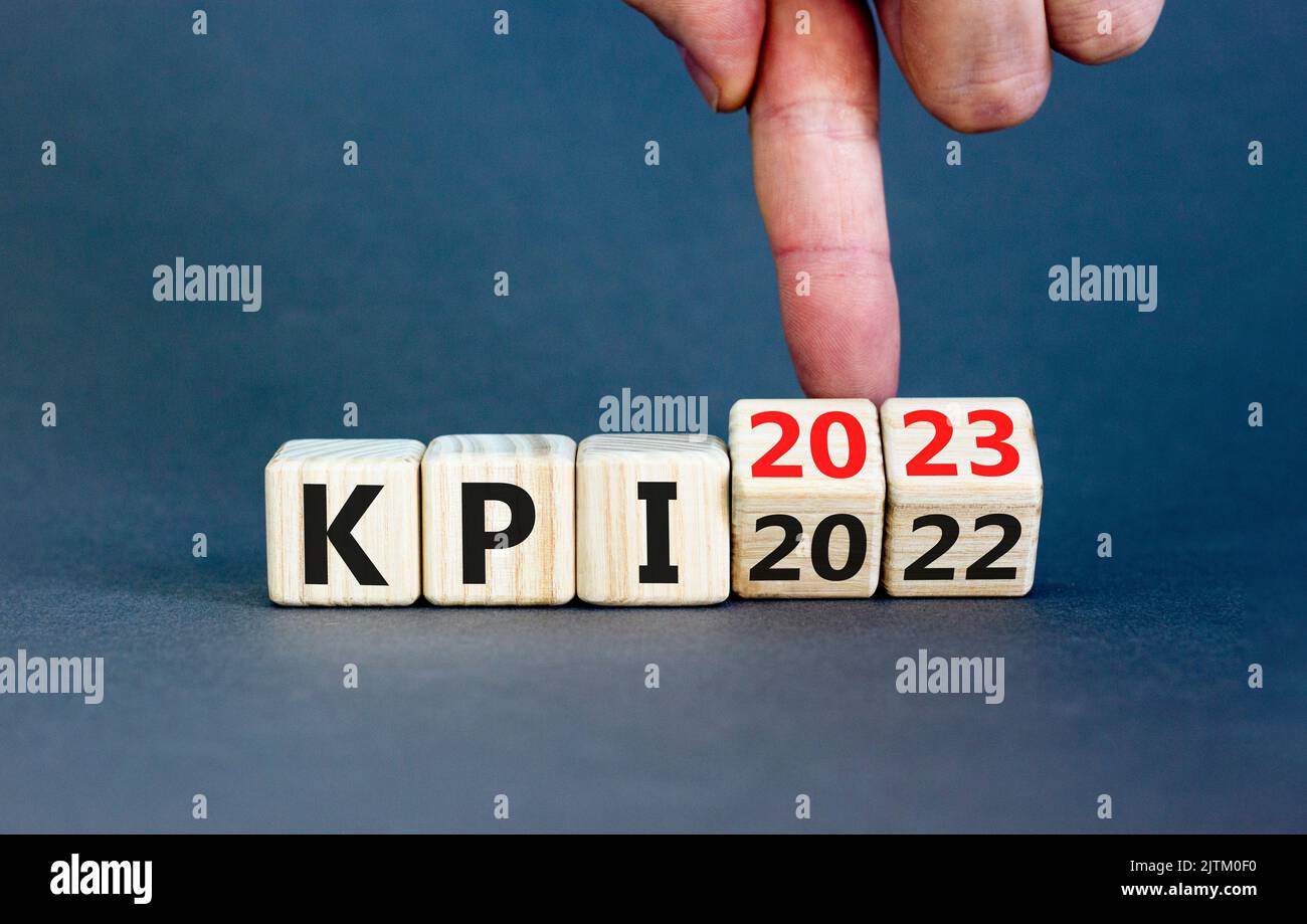 KPI, key performance indicator symbol. Businessman turns wooden cubes ...