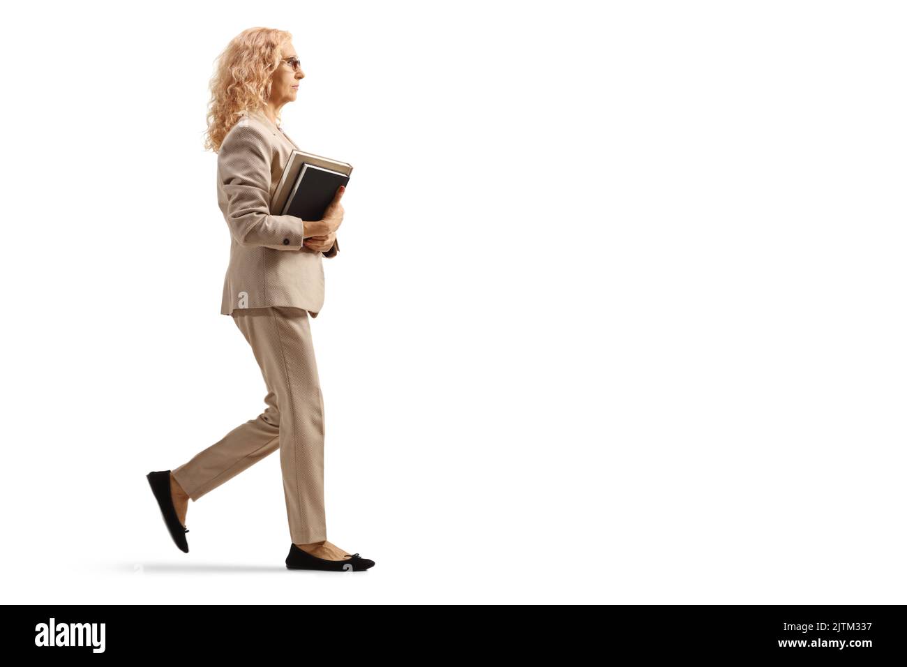 Full length portrait of a woman walking and carrying books isolated on ...