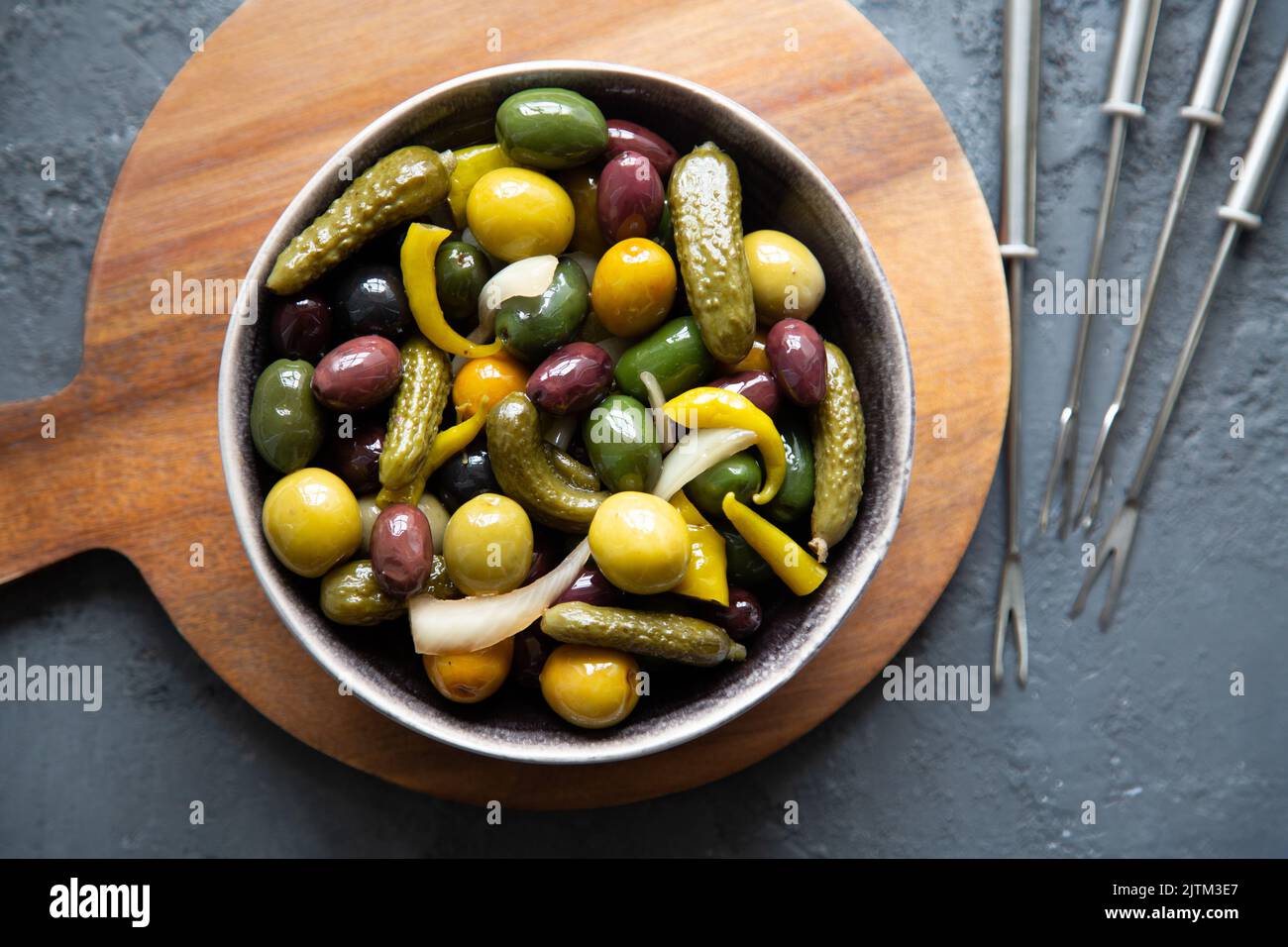 Pickled gherkins, onion, chilli and various types of olives in a bowl ...