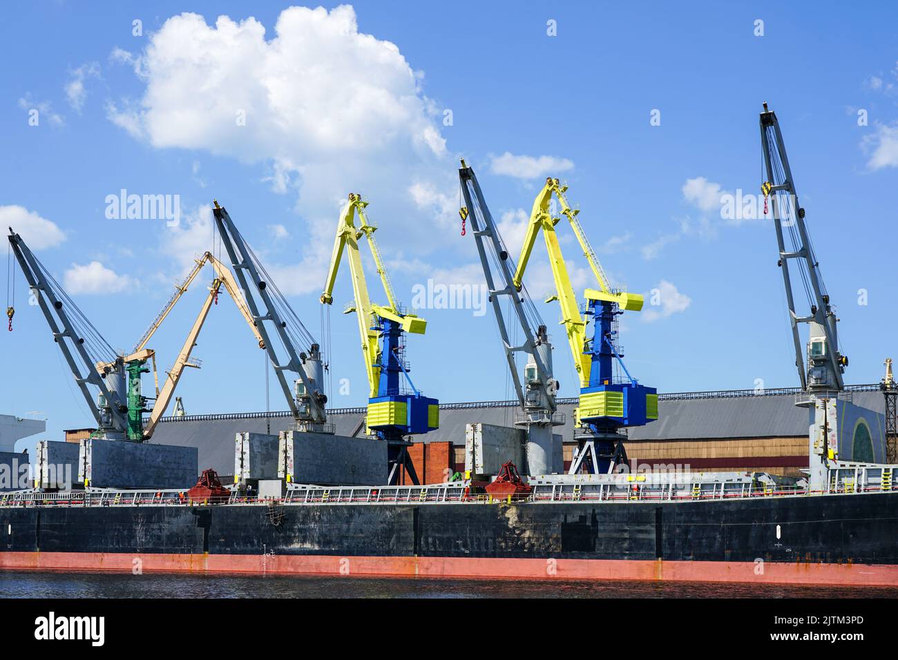 Bulk carrier with open storage tanks in port bulk terminal, port cranes ...