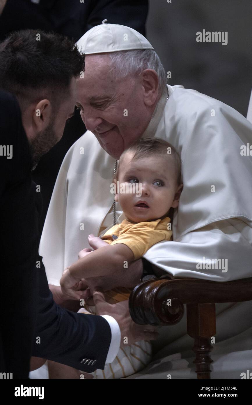 Vatican City, Vatican, 31 August 2022. Pope Francis holds a child in ...