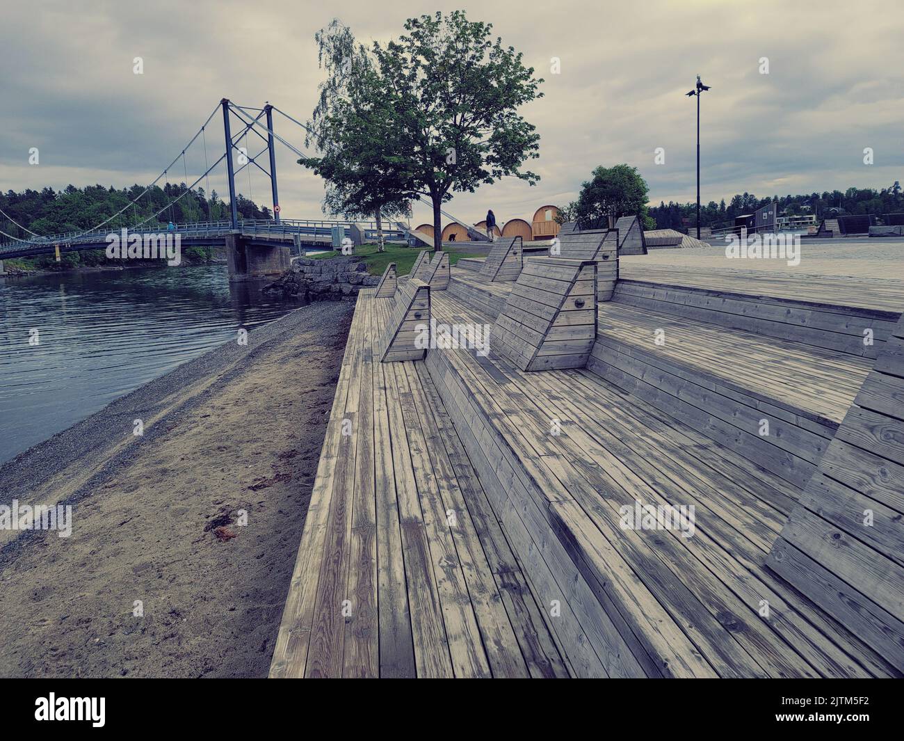 The wooden bench along the public park river with the bridge view Stock ...