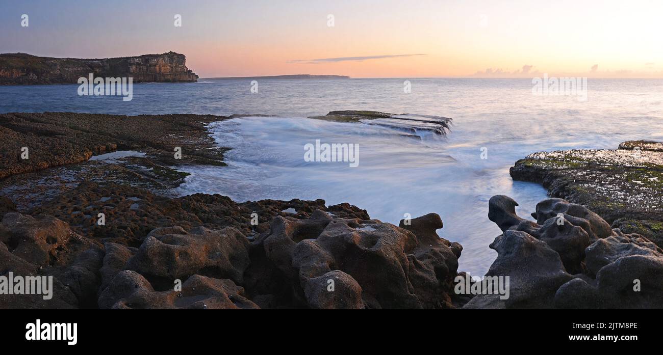 A landscape with ocean waves hitting a rocky coast Stock Photo - Alamy