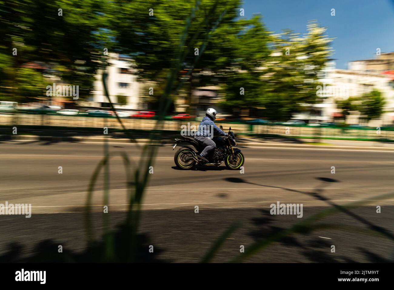 Biker on a motorcycle in traffic at rush hour in downtown area of the ...