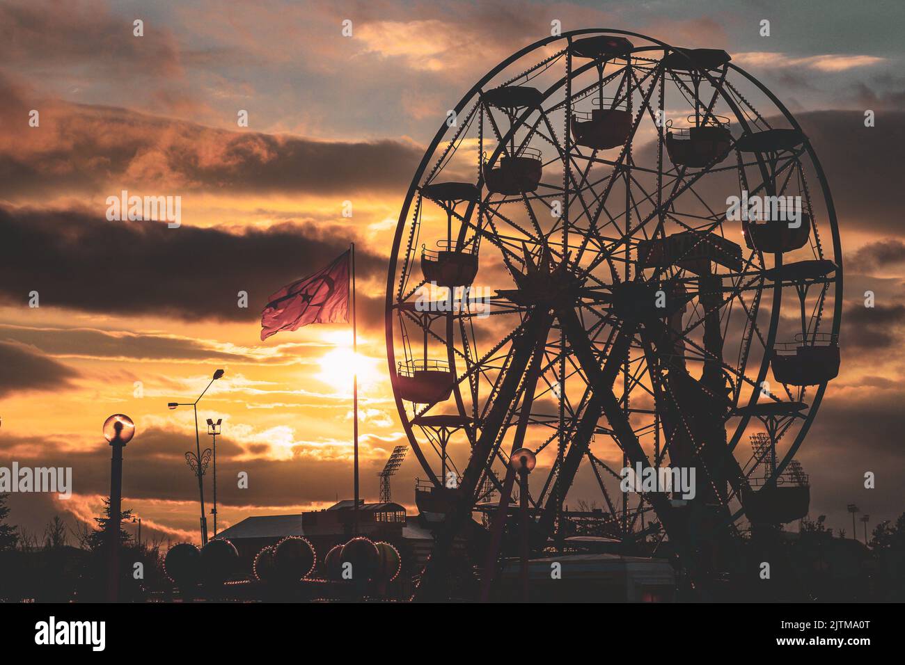 Sunset in the background. Ferris wheel silhouette. waving turkish flag ...
