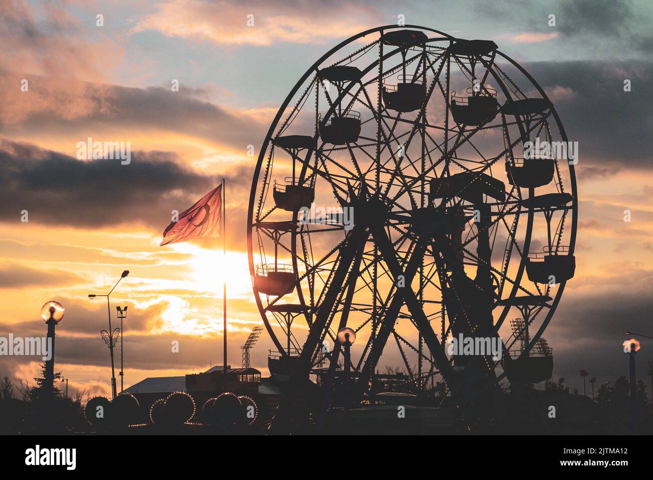 Sunset in the background. Ferris wheel silhouette. waving turkish flag ...
