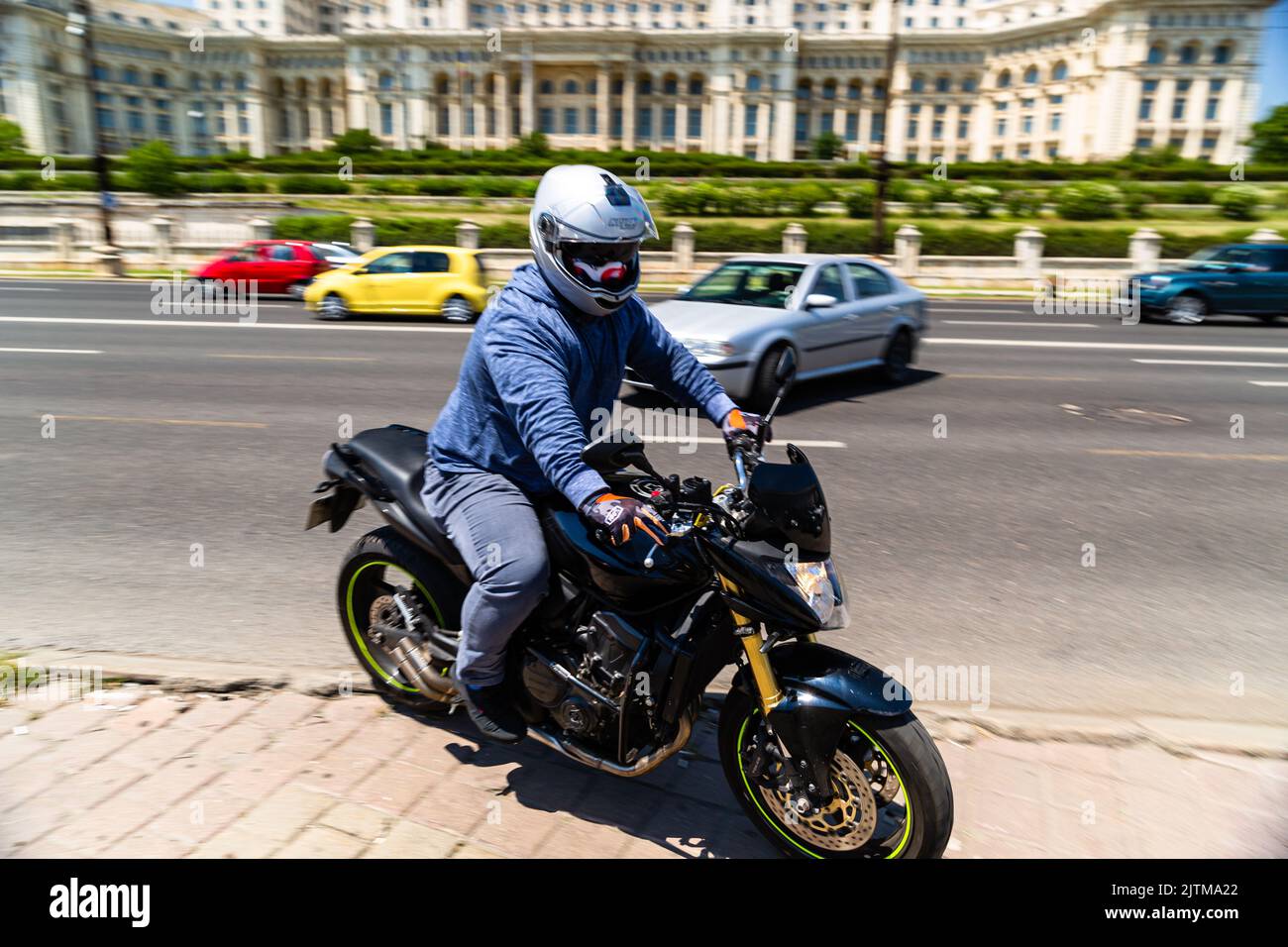 Biker on a motorcycle in traffic at rush hour in downtown area of the ...