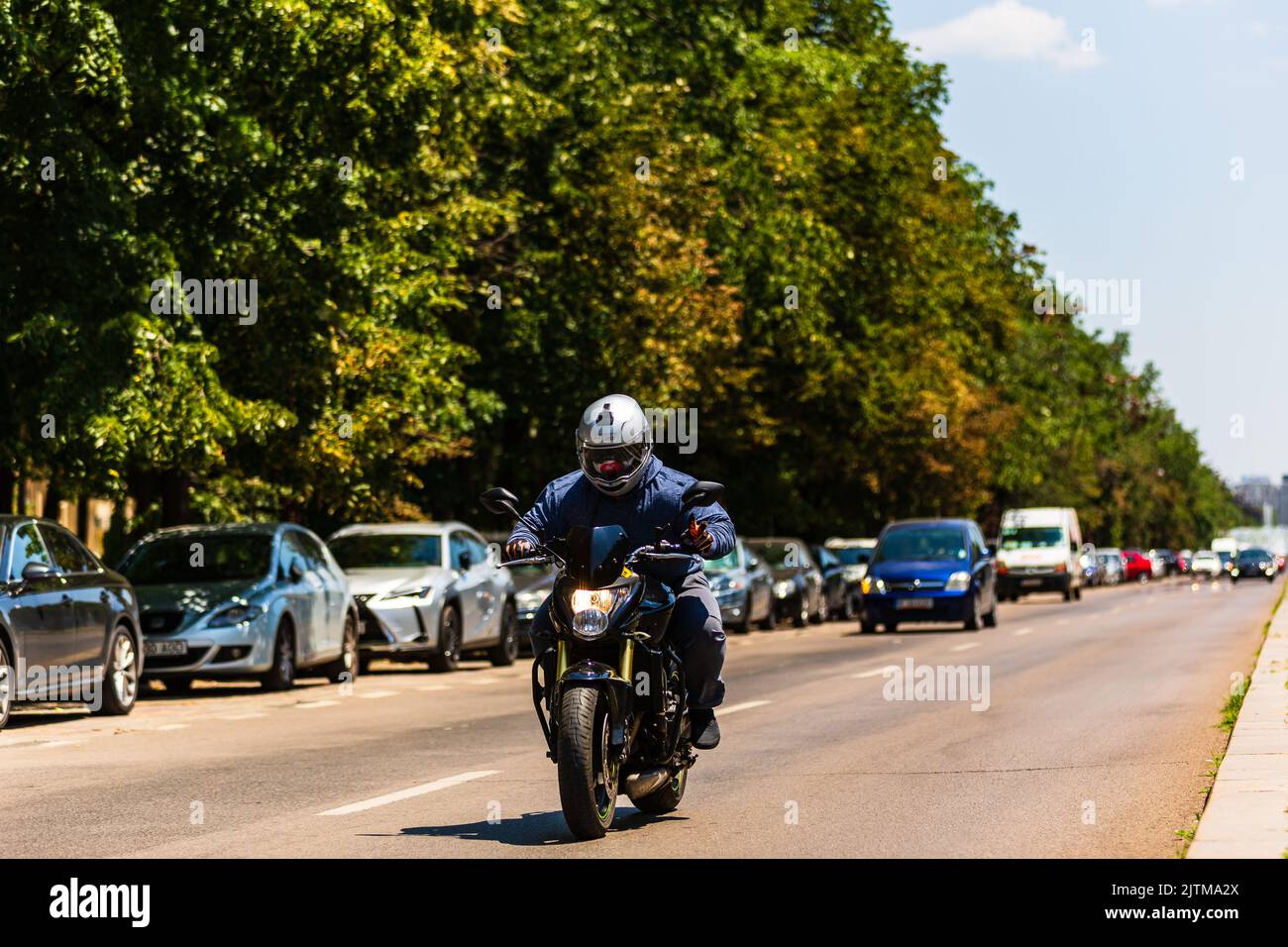 Biker on a motorcycle in traffic at rush hour in downtown area of the ...