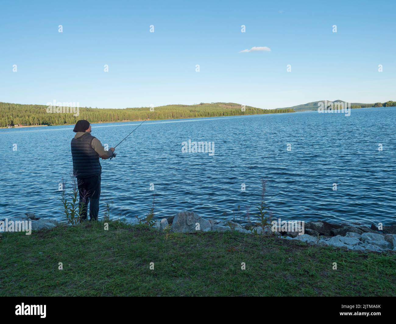 Fisherman at Lule river, in clear calm Lille Lulealven fresh water in ...