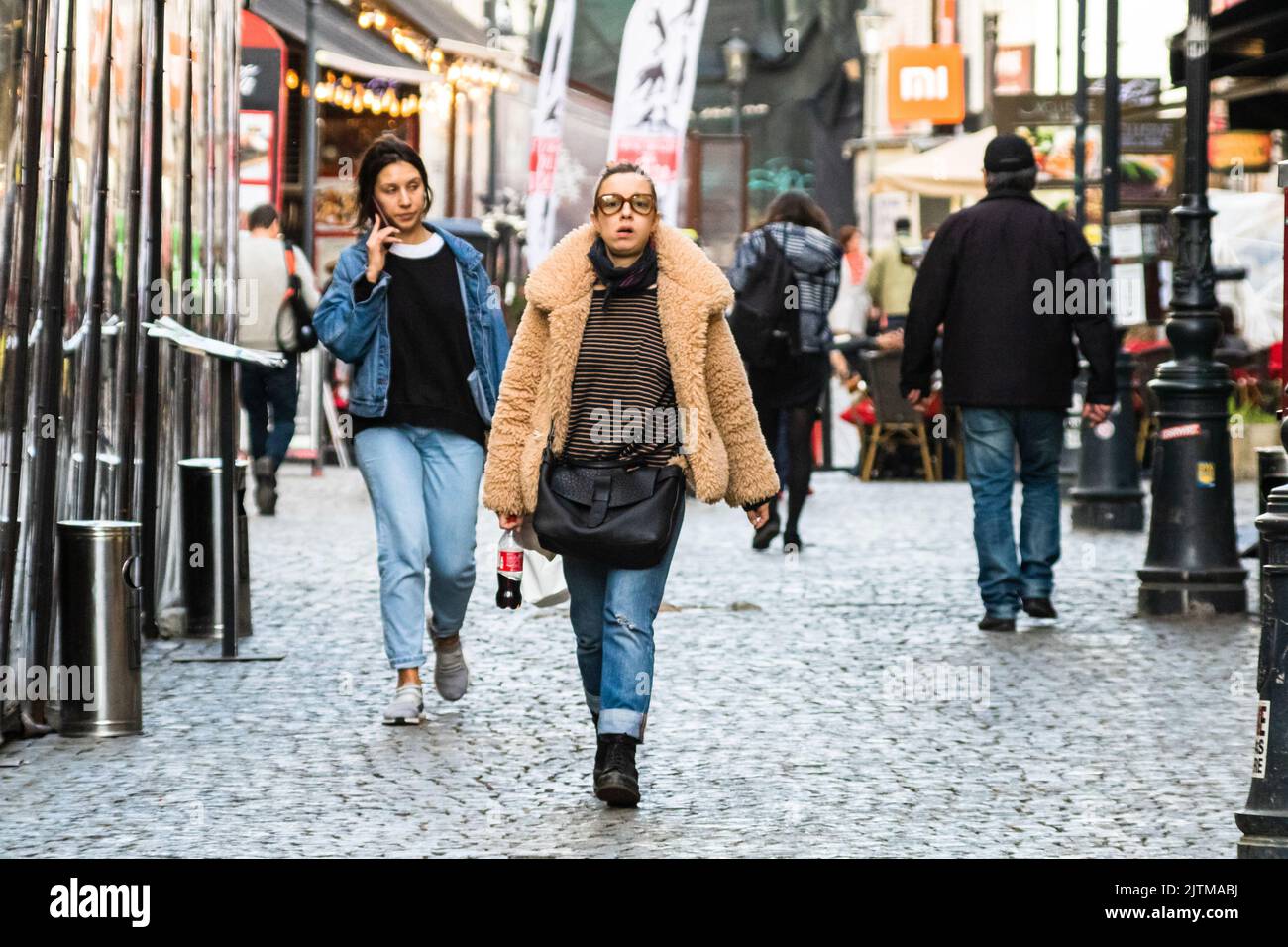 People and tourists wander the streets of the Bucharest Old Town ...