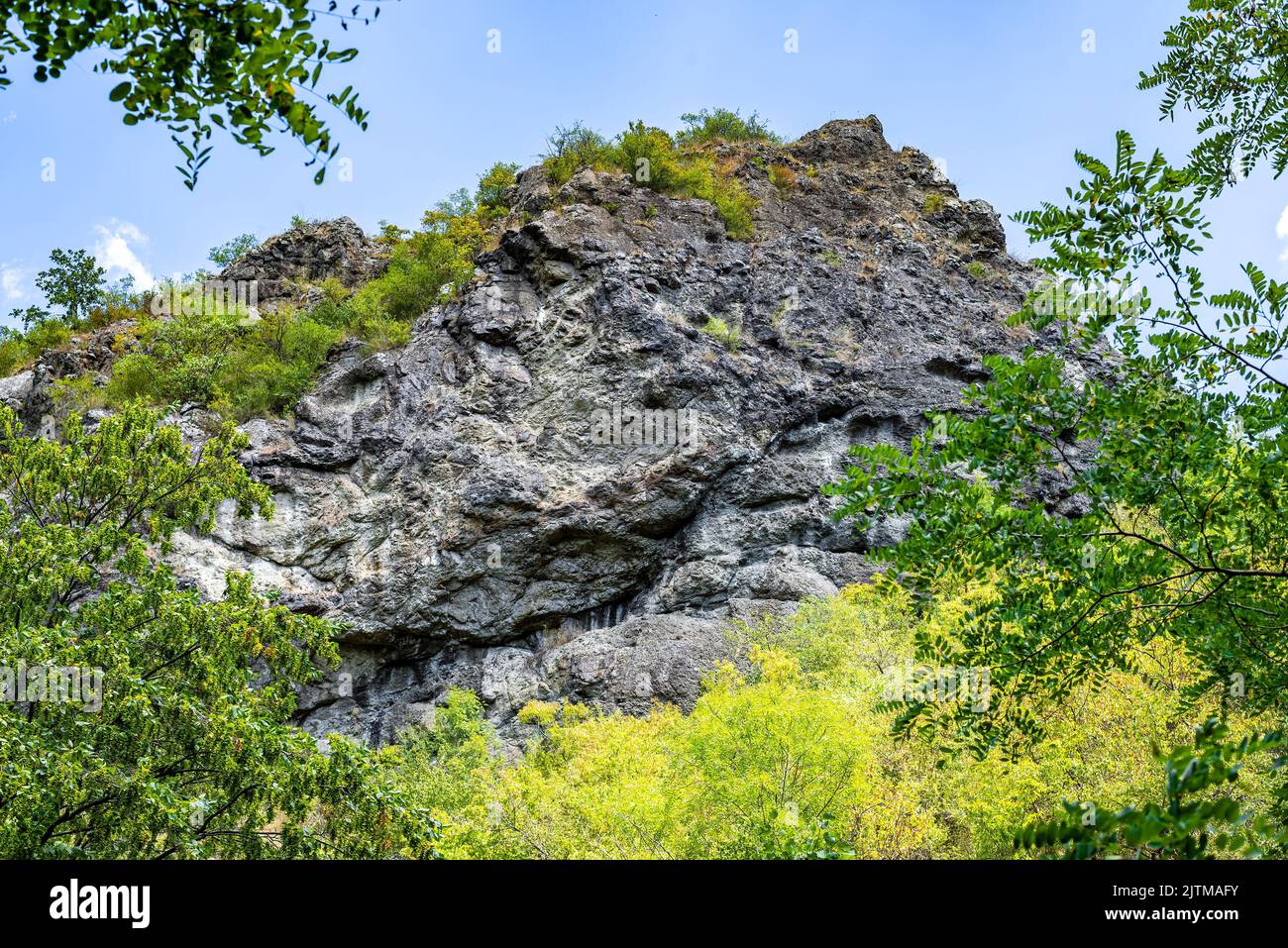 The rocky cliffs above the forest against a blue sky background Stock ...
