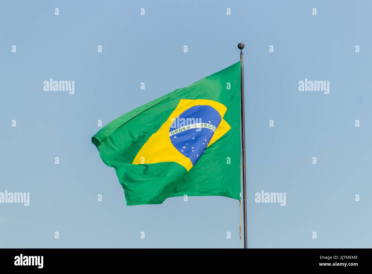 Brazilian flag flying with blue sky background in Rio de Janeiro Stock ...