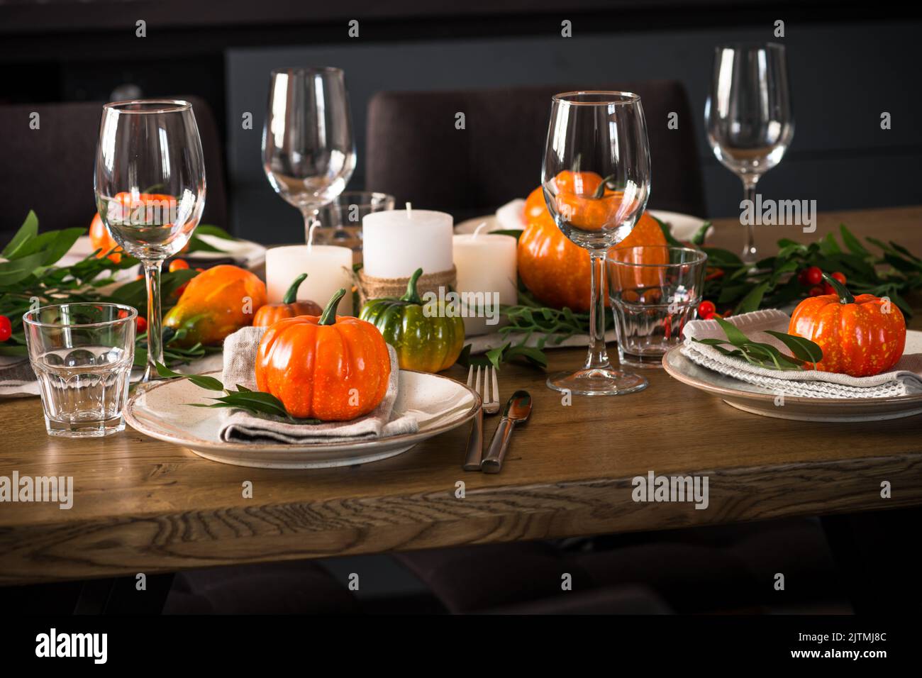 Autumn table setting with plate, pumpkin and candles Stock Photo - Alamy