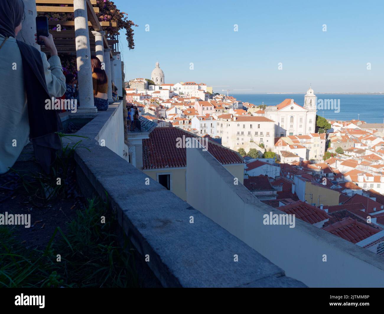 Tourist takes a photo from the Viewpoint Miradouro de Santa Luzia ...