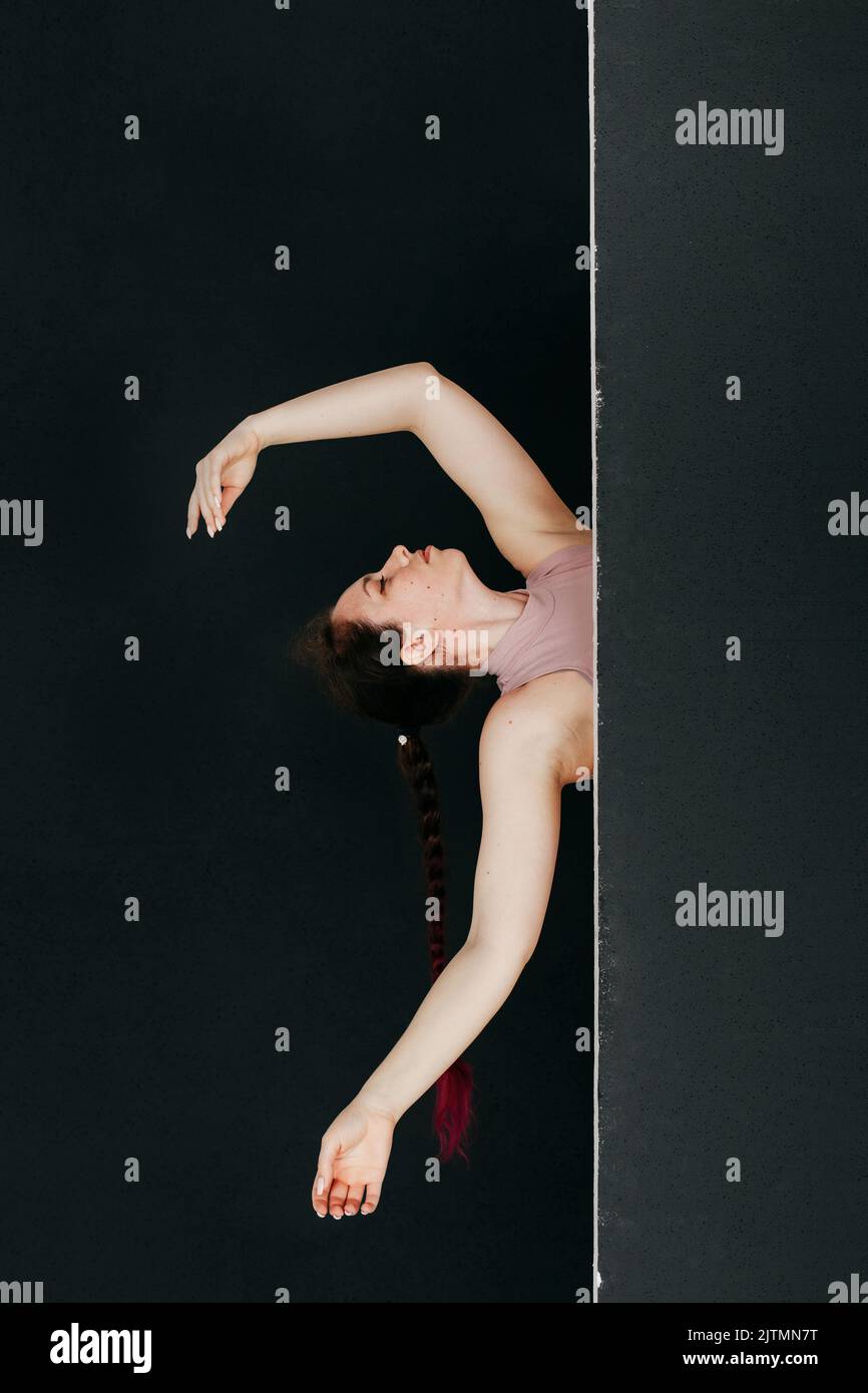 A beautiful brunette peeks out from behind a black screen. Studio ...