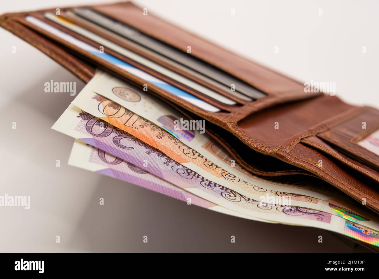 a light brown leather wallet with bank cards and a detailed close-up of ...