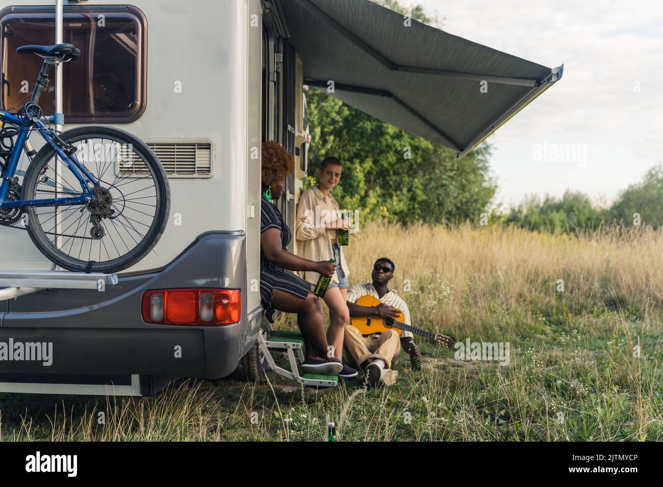 Interracial friendship on a camping van trip with bicycles. Diverse ...