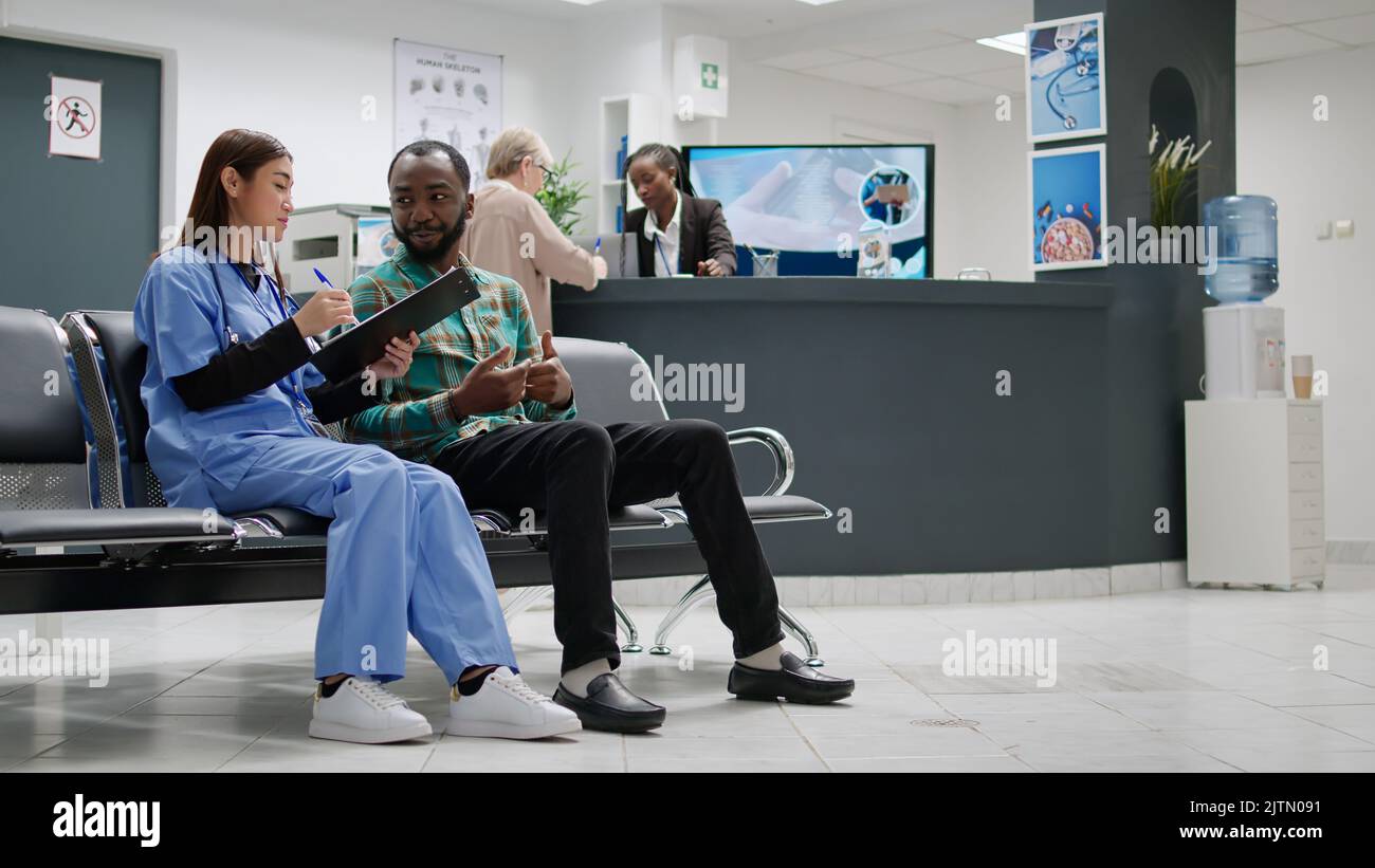Diverse people doing consultation appointment in hospital reception ...