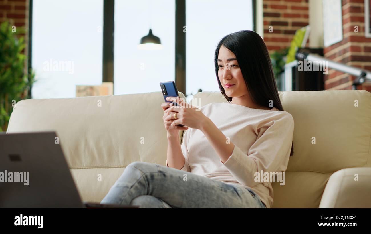 Happy freelancer answering client email on smartphone while working ...