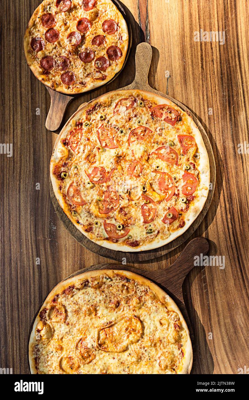 Three pizzas of different flavors. Pepperoni, cheese, potato, onion ...