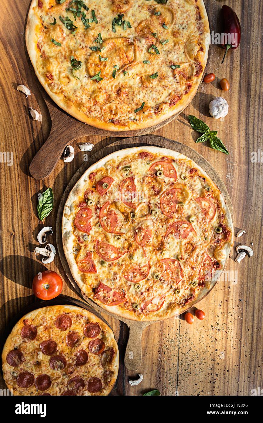 Three pizzas of different flavors. Pepperoni, cheese, potato, onion ...