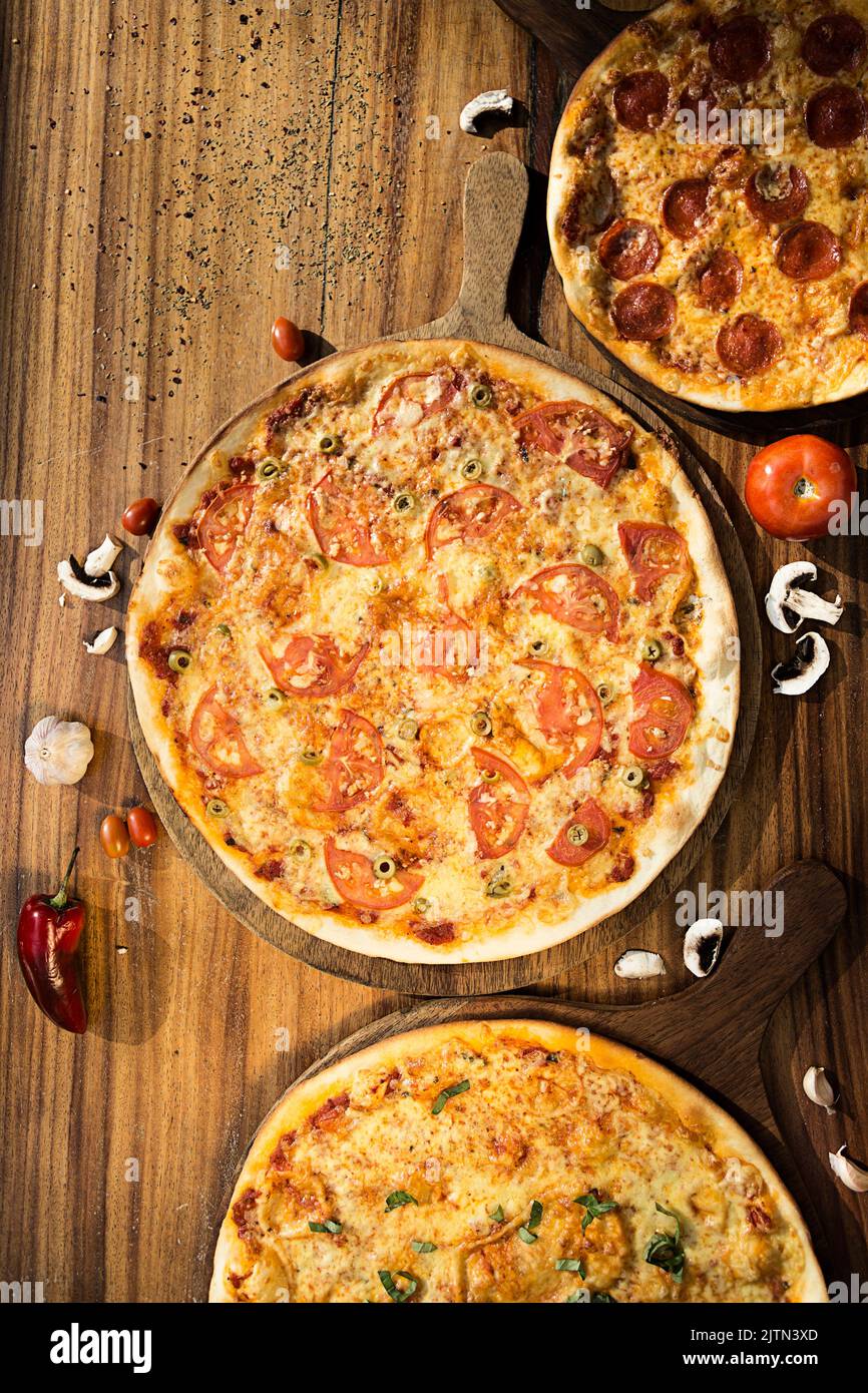 Three pizzas of different flavors. Pepperoni, cheese, potato, onion ...