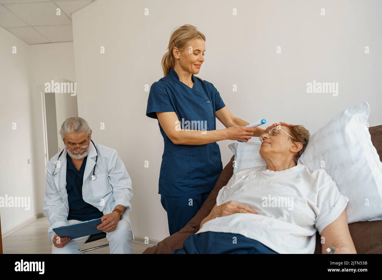 Doctor measures patient's temperature with non-contact thermometer in ...