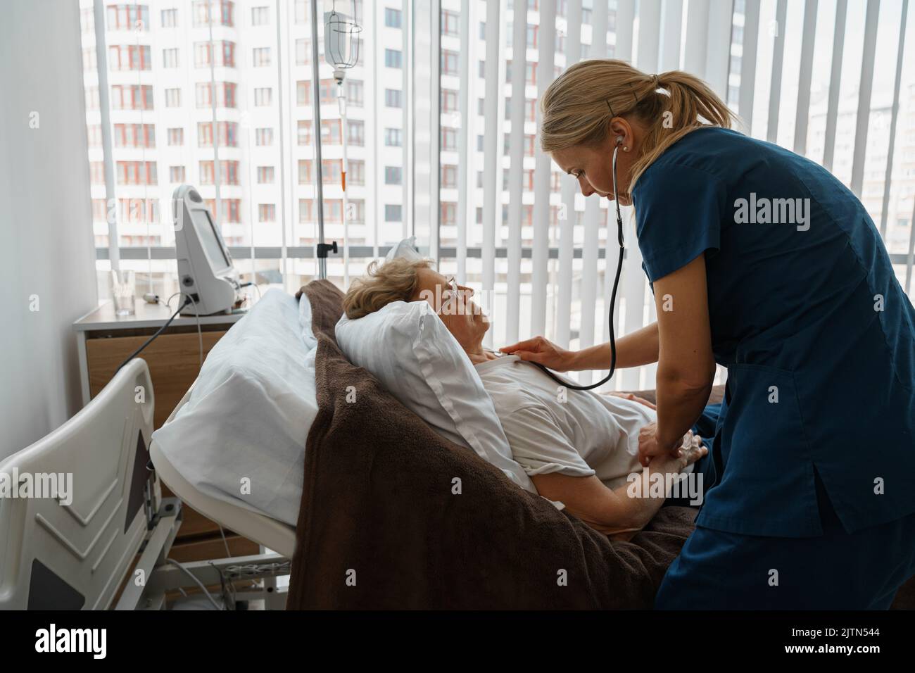 Female doctor therapist listening to old woman's patient breathing ...
