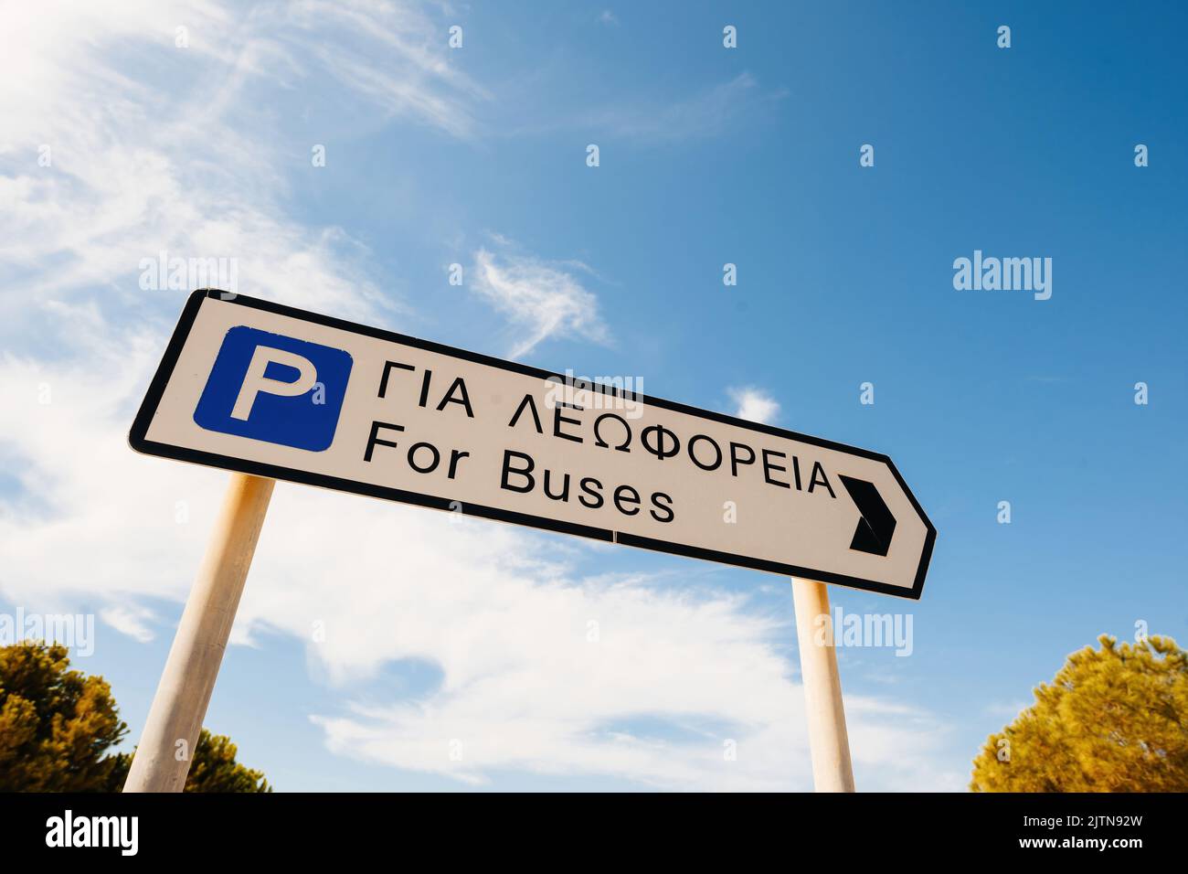 Parking signal with clouds trees and sky on background text in greek ...