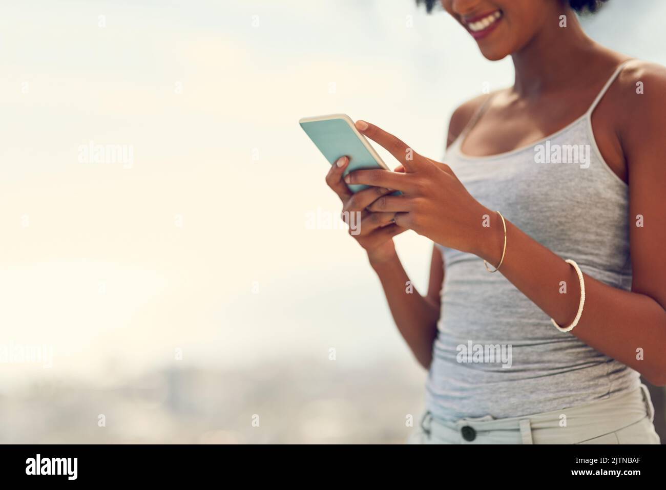 Lets make some weekend plans. a young woman texting on her cellphone ...