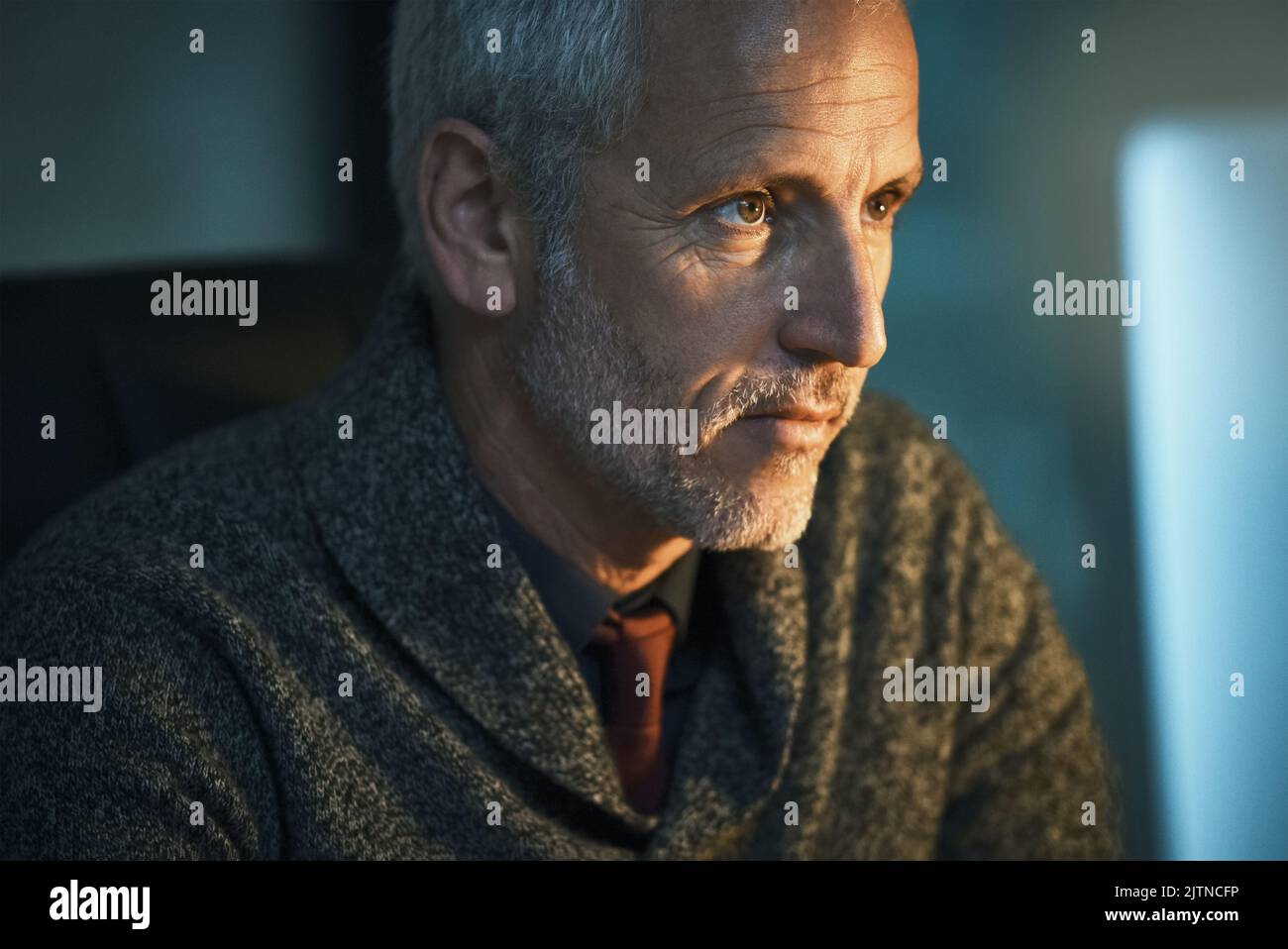 Long days and late nights. a mature businessman working late at the ...