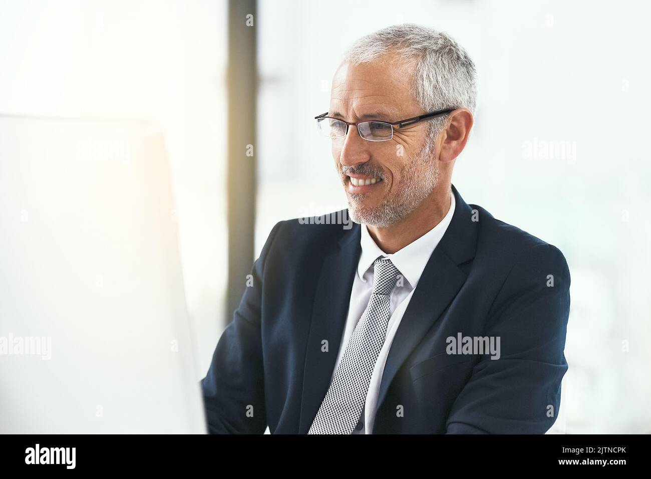 His work is shaping up nicely. a smiling mature businessman working on ...