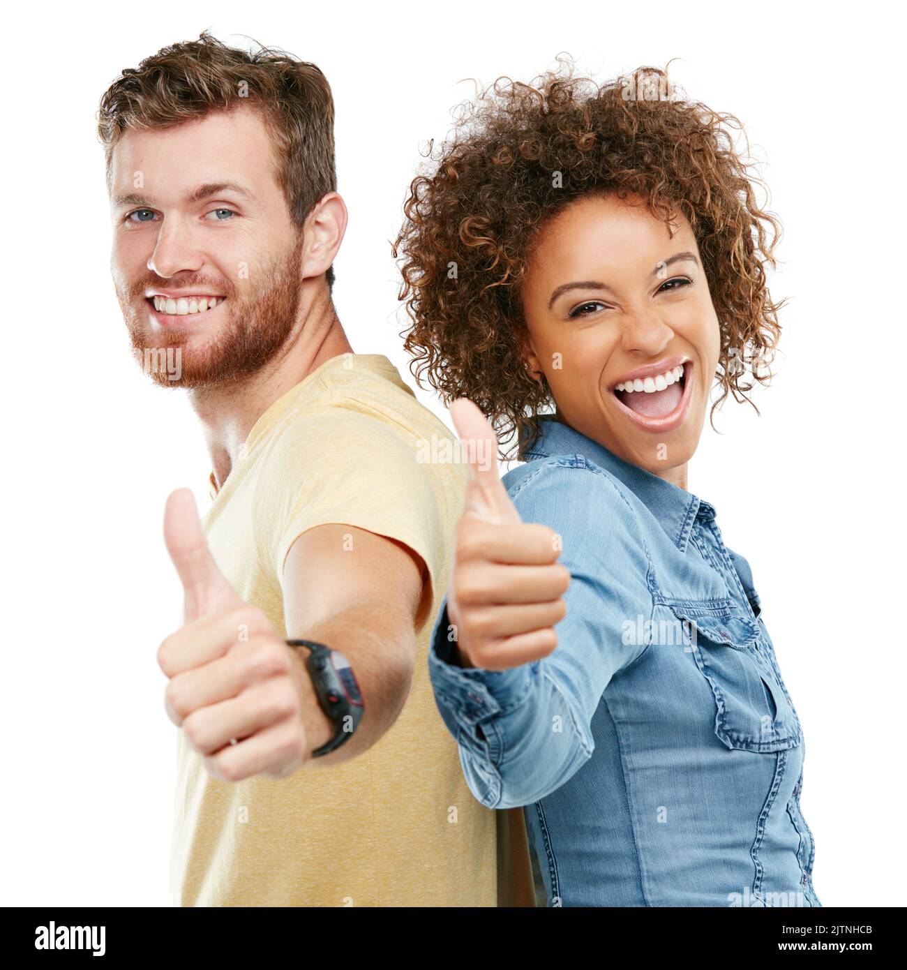 Yeah. Studio portrait of a young couple giving a thumbs up to the camera against a white ...