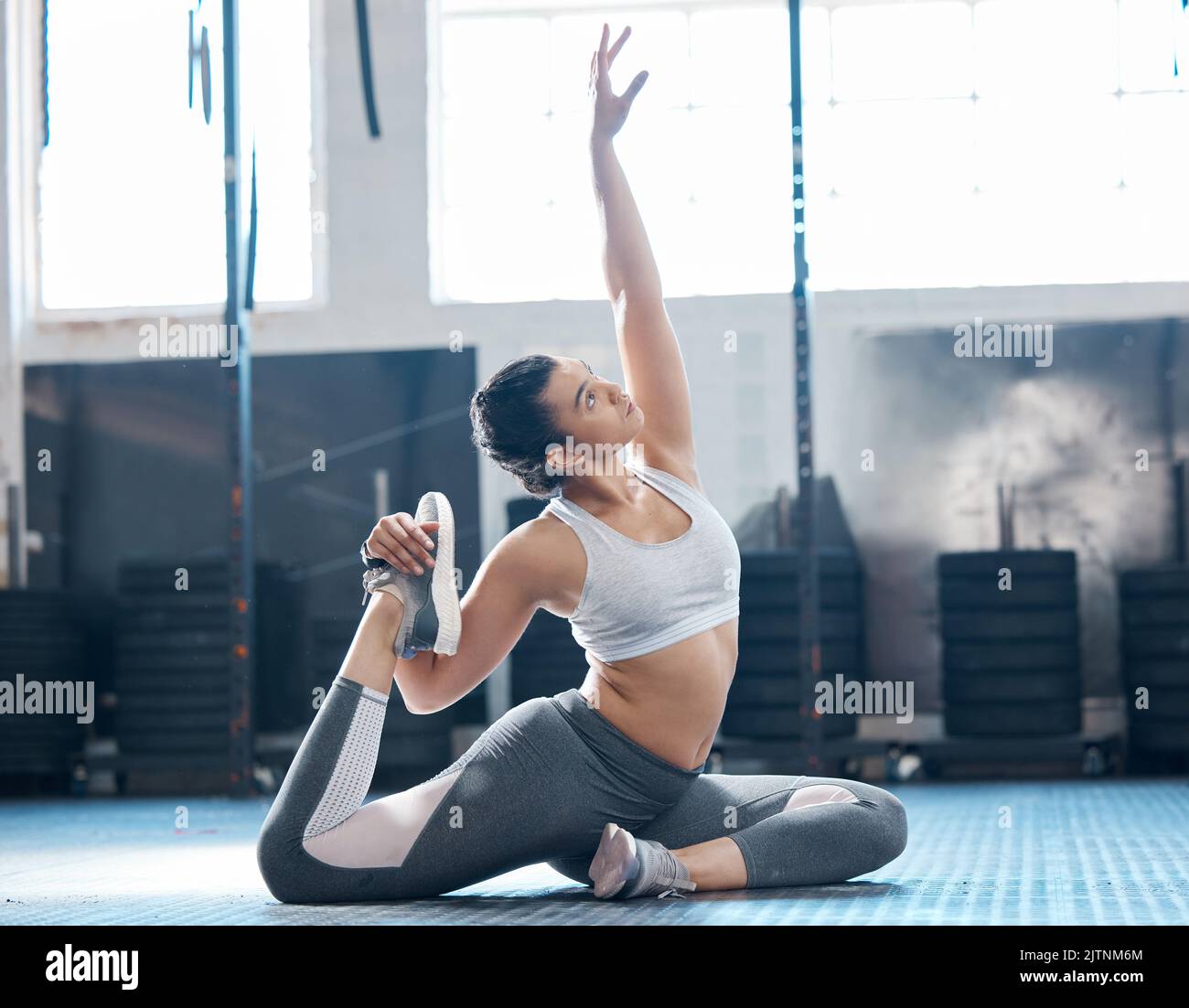 Yoga, gym or workout by a fit woman stretching for her exercise or ...