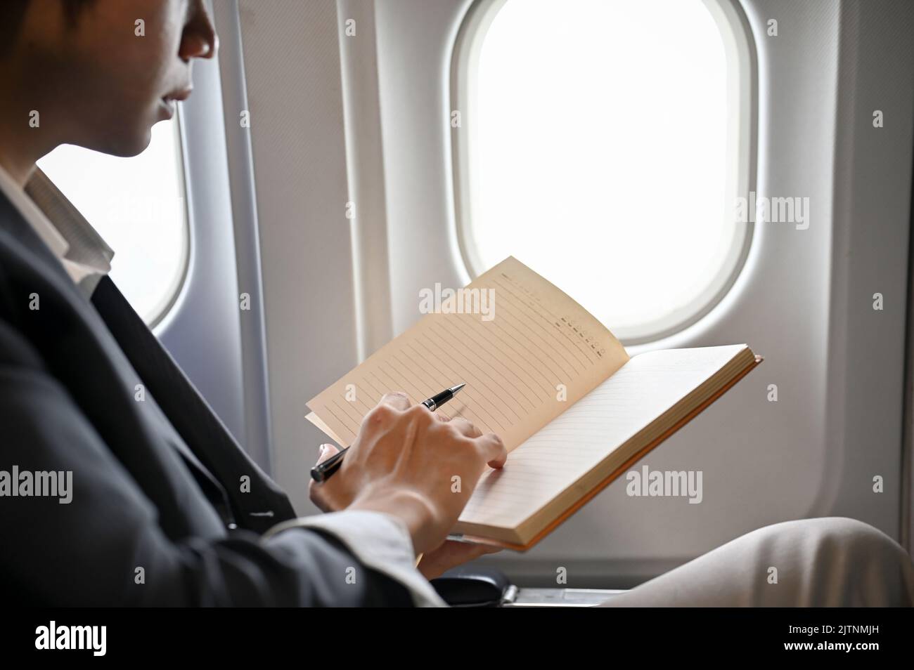 Smart and professional young Asian businessman is on the flight ...