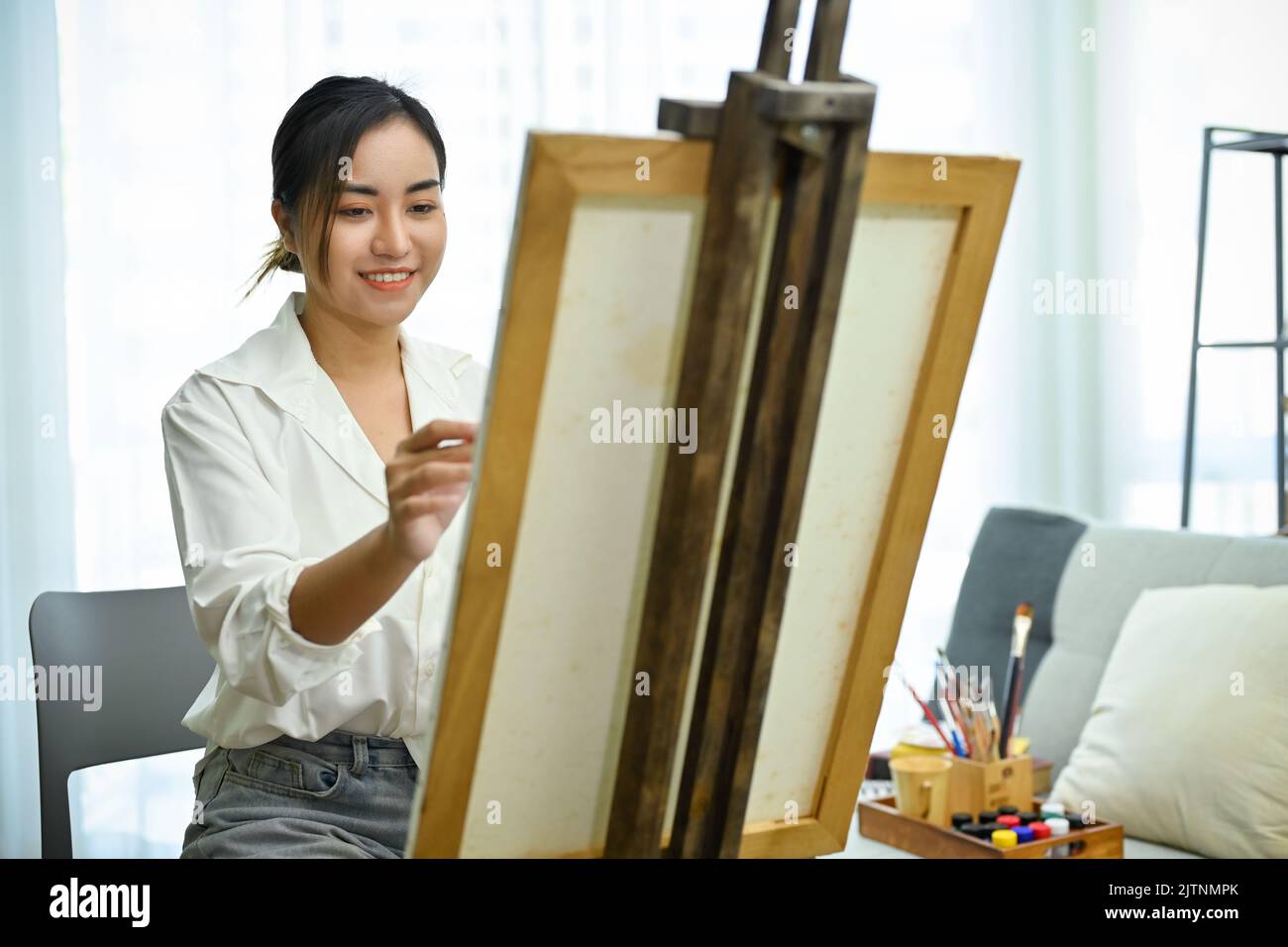 Beautiful talented Asian female artist coloring her artwork on a large ...