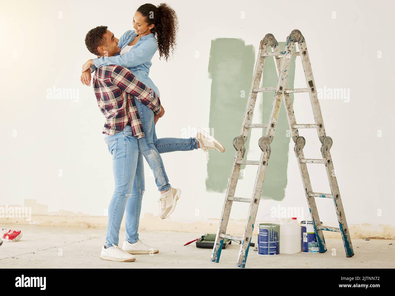Love couple smile painting house or home interior with paint and ladder ...