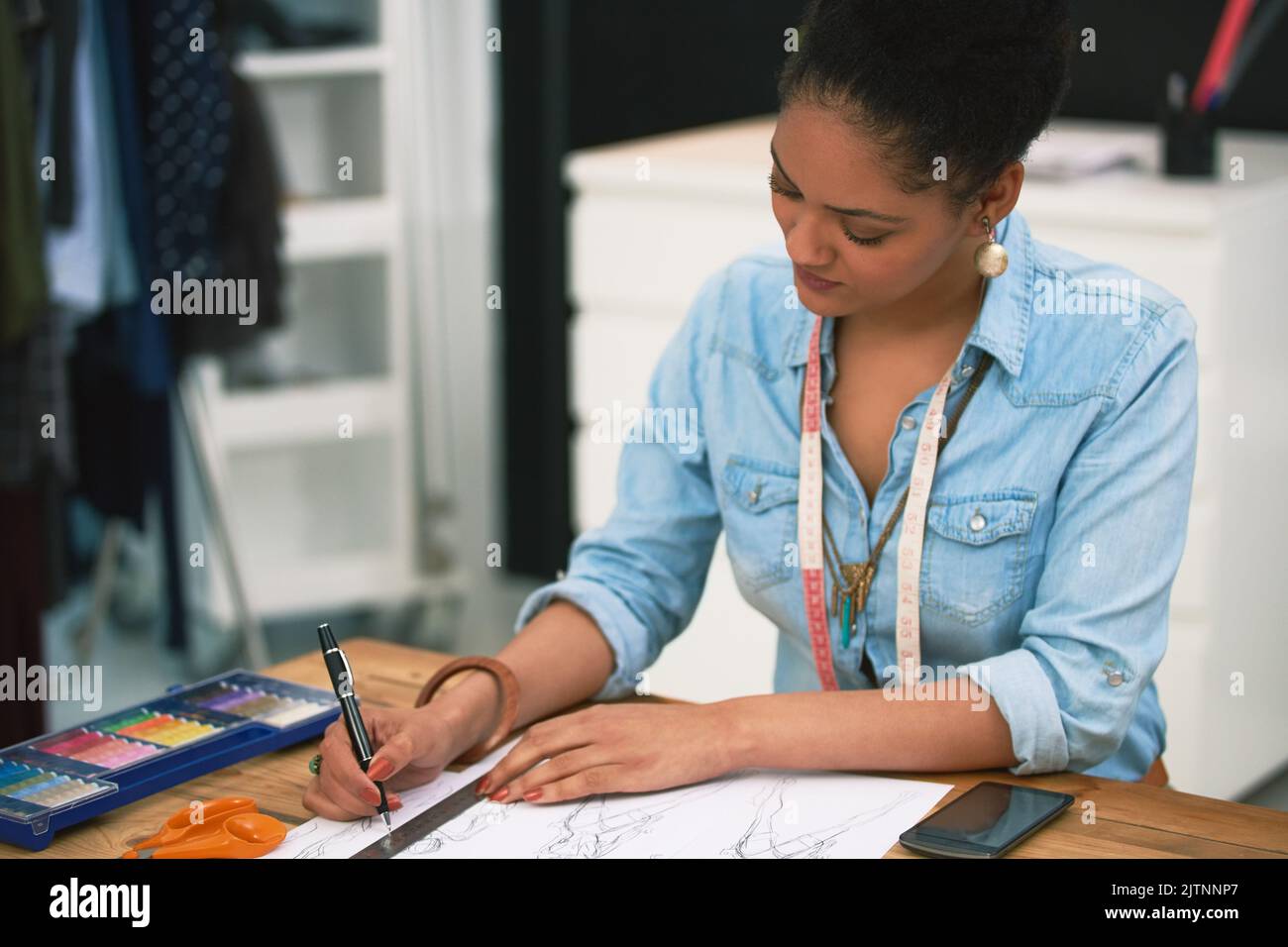 Let her design it for you. an attractive young designer sketching a new ...