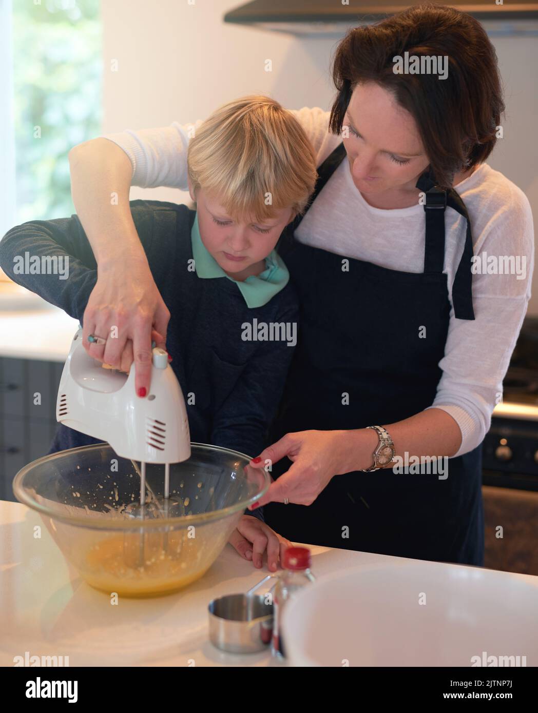 Youre never too young to learn to bake. a mother teaching her little ...