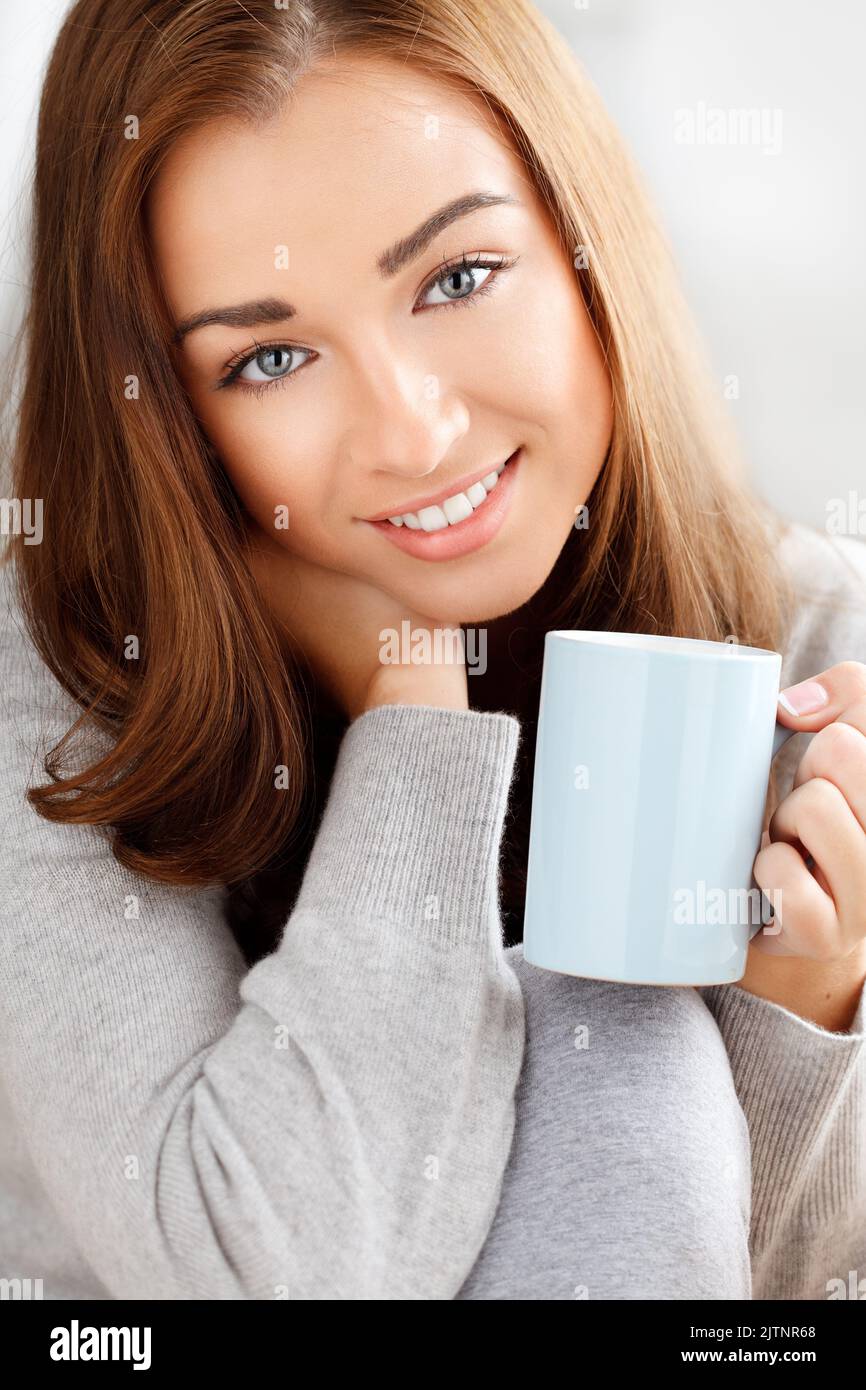 Portrait, woman drinking tea or coffee against a studio background and ...