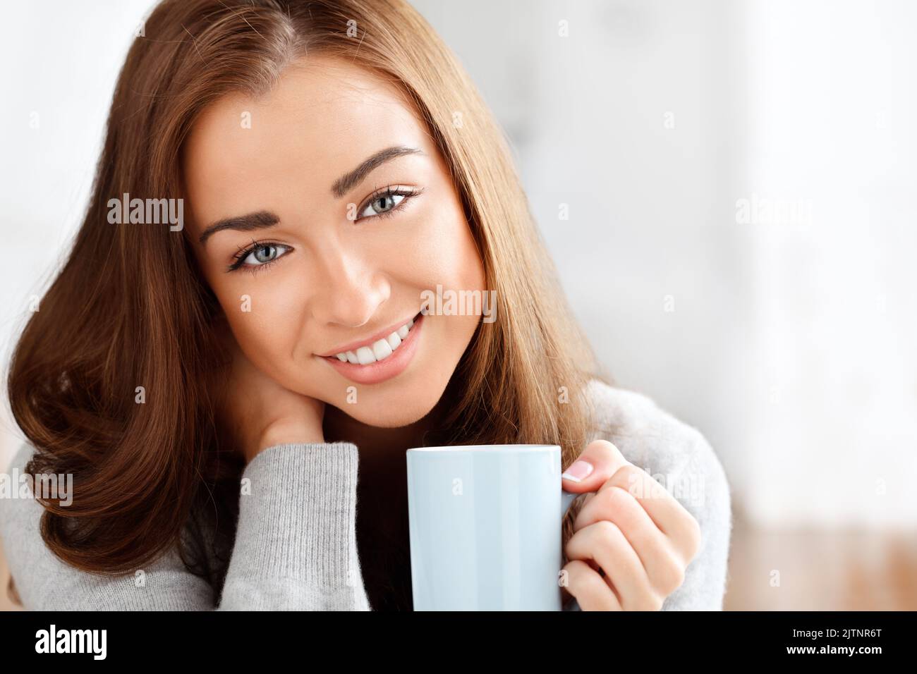 Happy, relax and smile of a girl teenager at home with coffee or tea ...